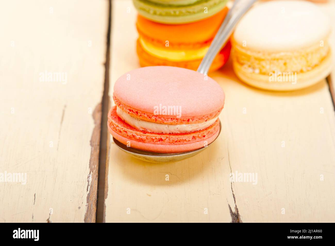colorful french macaroons over a white rustic wood table Stock Photo ...