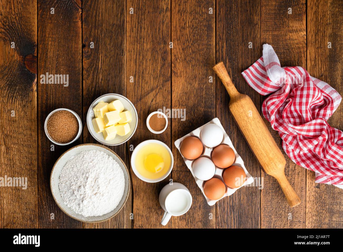 Baking ingredients on rustic wooden table background. Flour eggs sugar ...