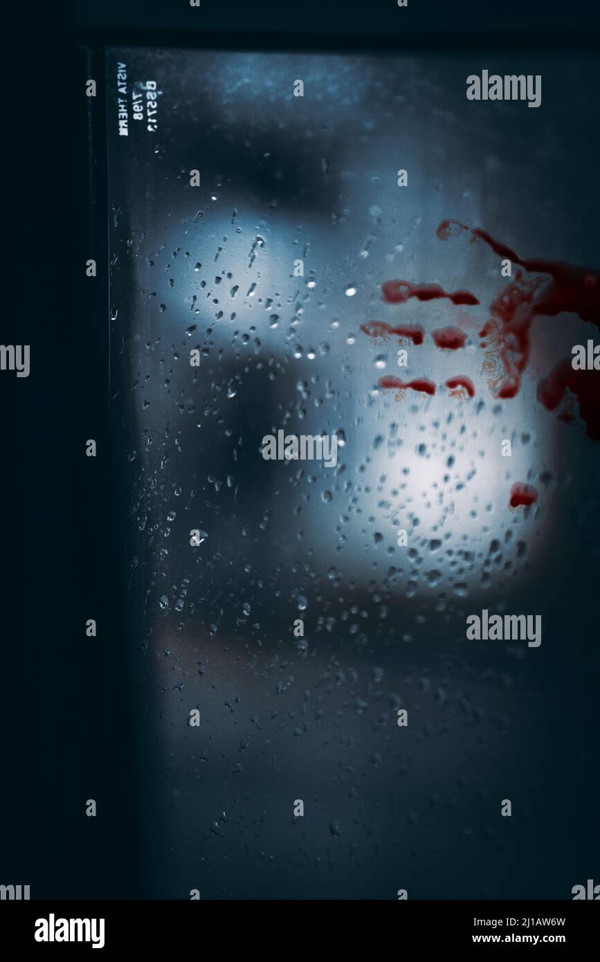 A vertical shot of a bloody handprint on a wet window Stock Photo - Alamy
