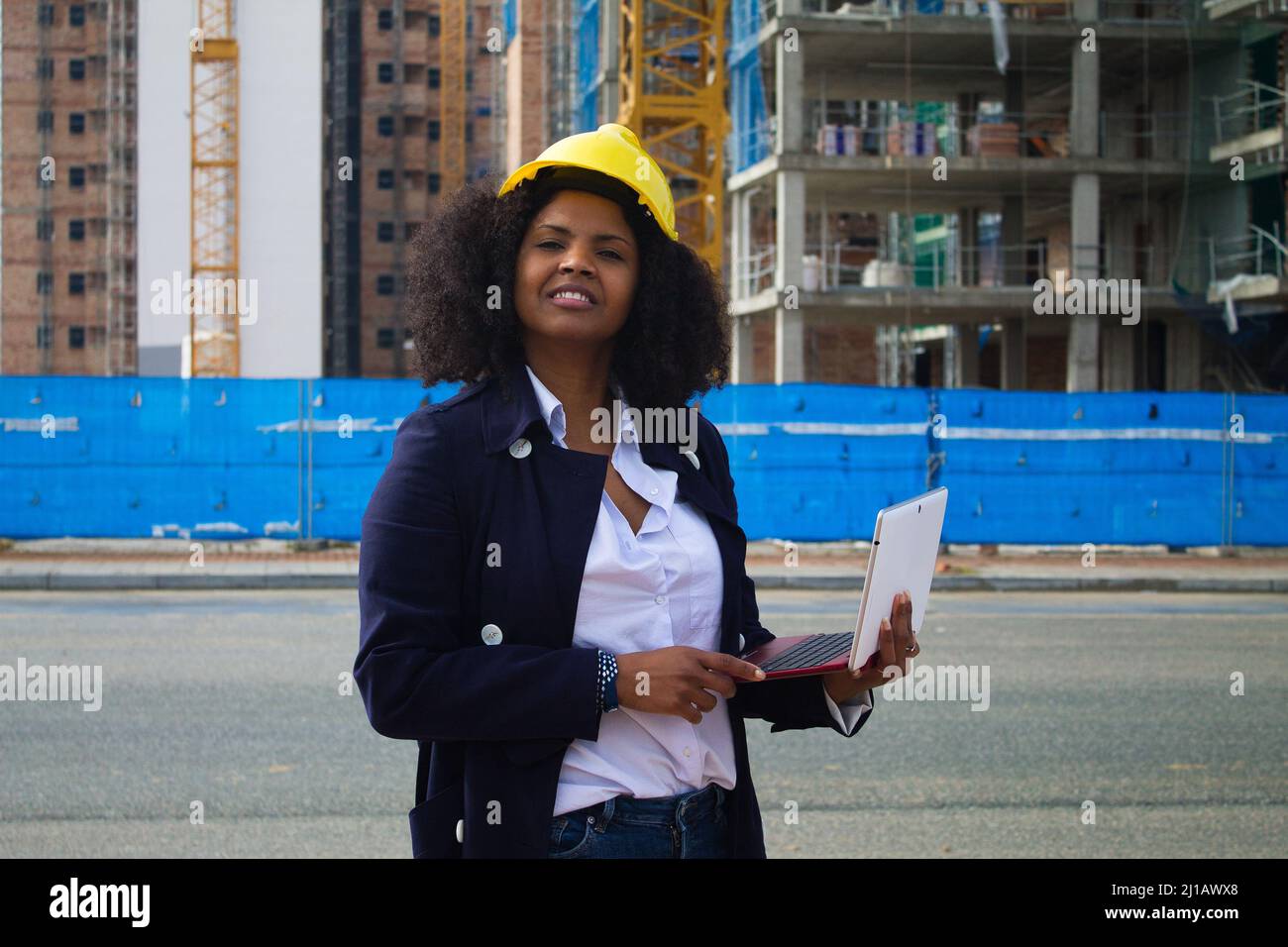 An African-American black woman construction manager in a yellow ...