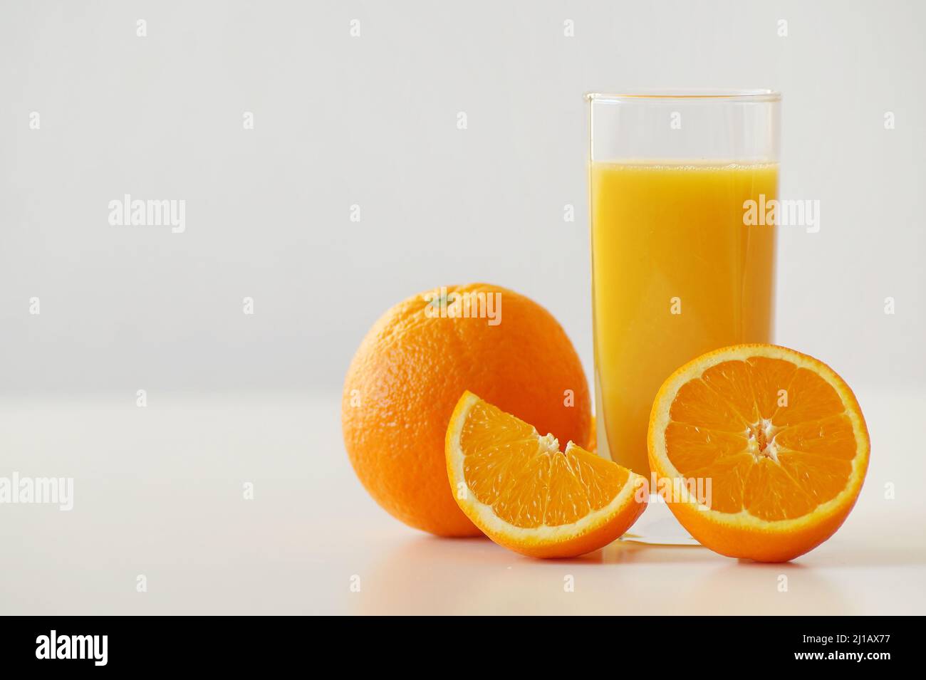 A horizontal photo showing a glass of freshly squeezed orange juice and ...