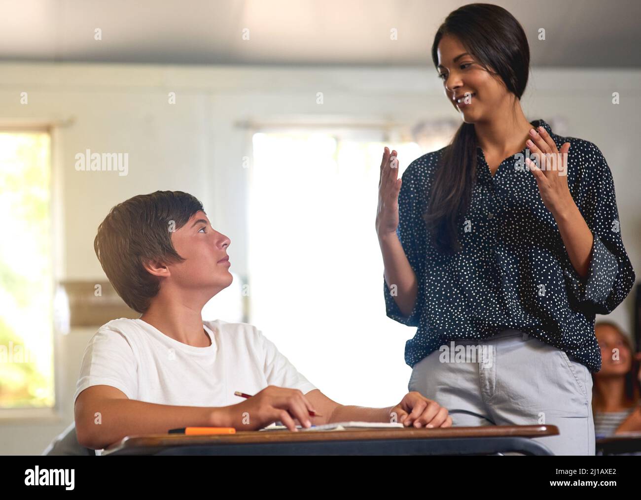 This teacher has all the answers. Shot of a young teacher explaining ...