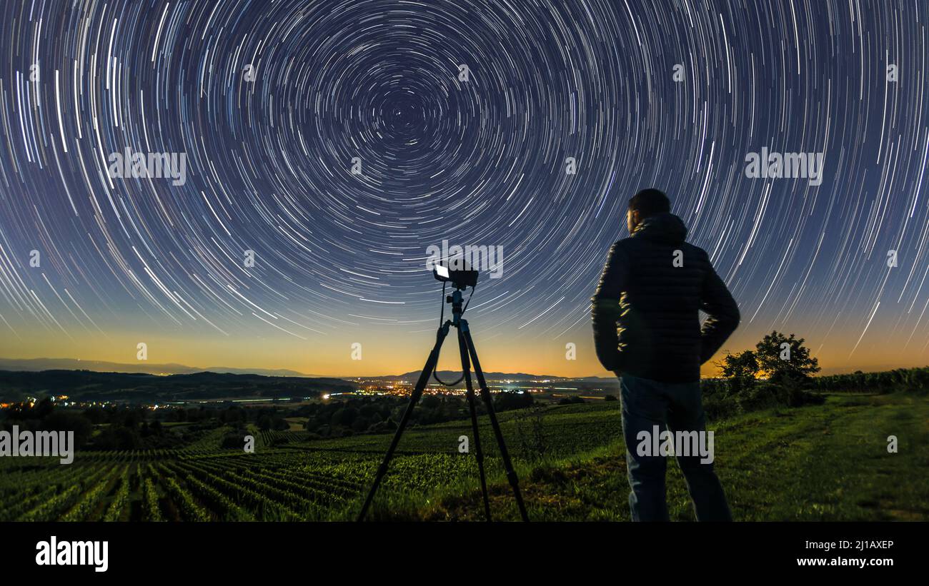 A man standing in the field with stars captured with long exposure ...