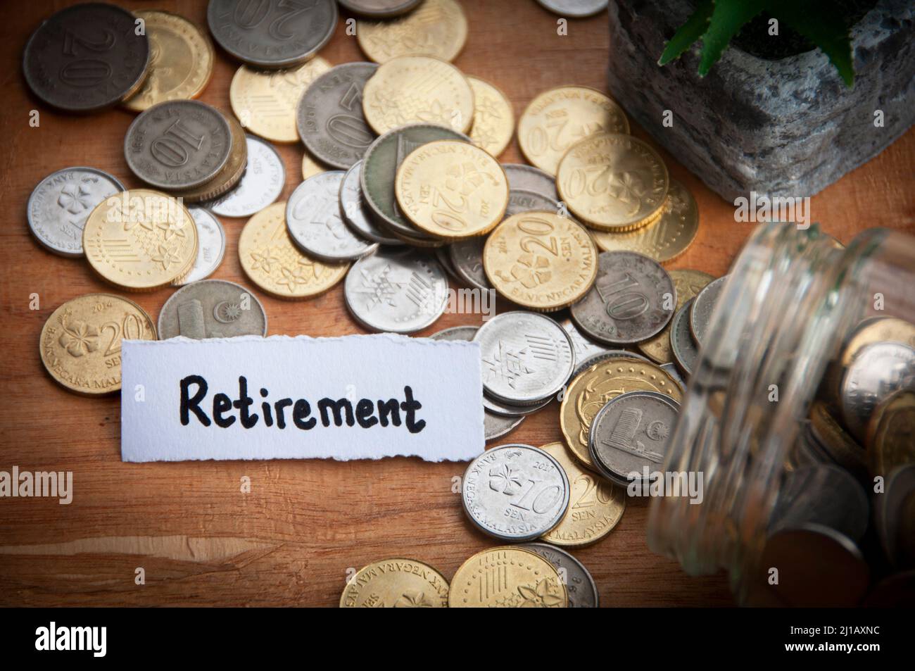 Retirement text on torn paper with coins and wooden table background ...