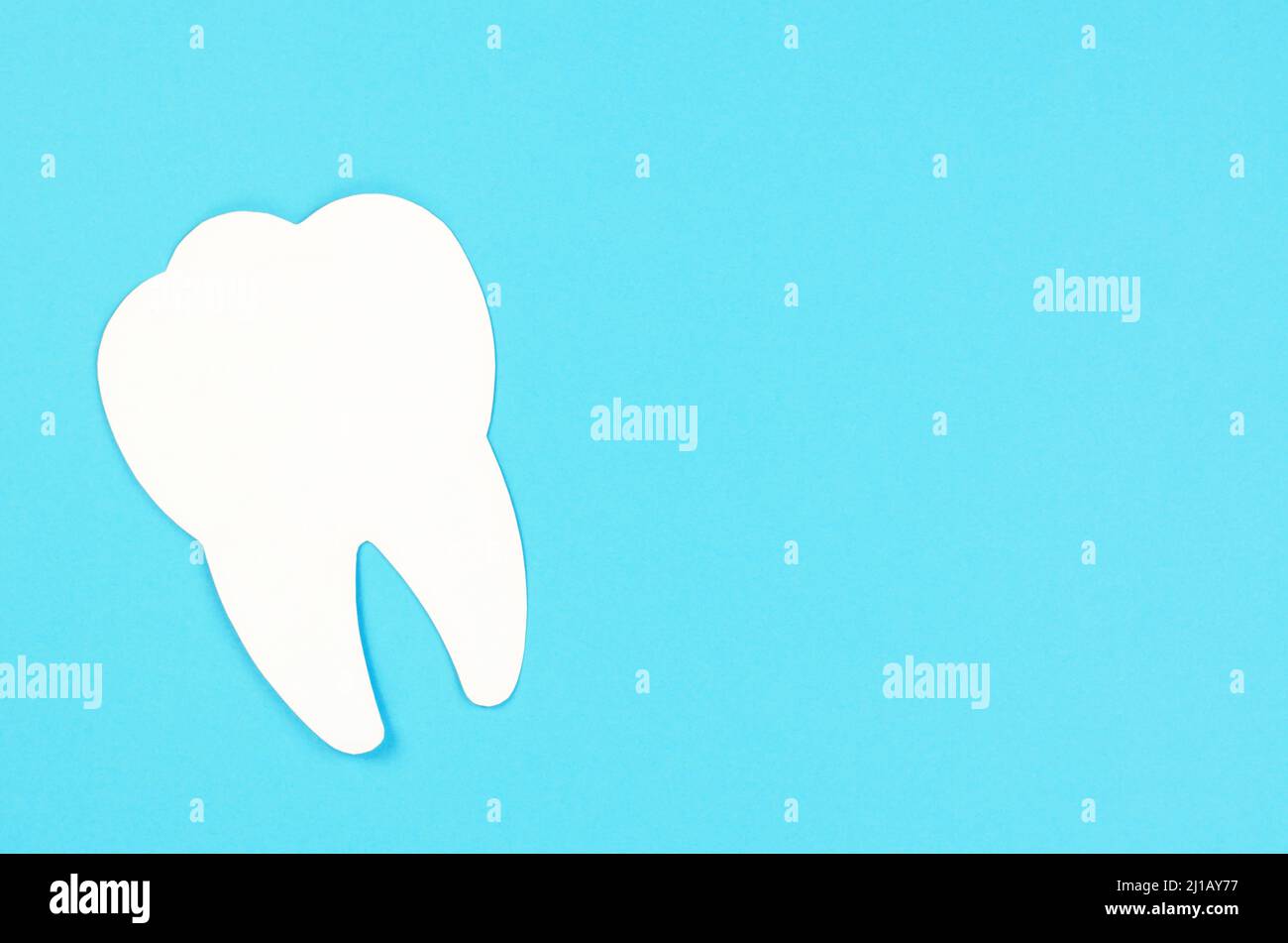 Big white tooth on a blue background. Dental care concept, copy space ...