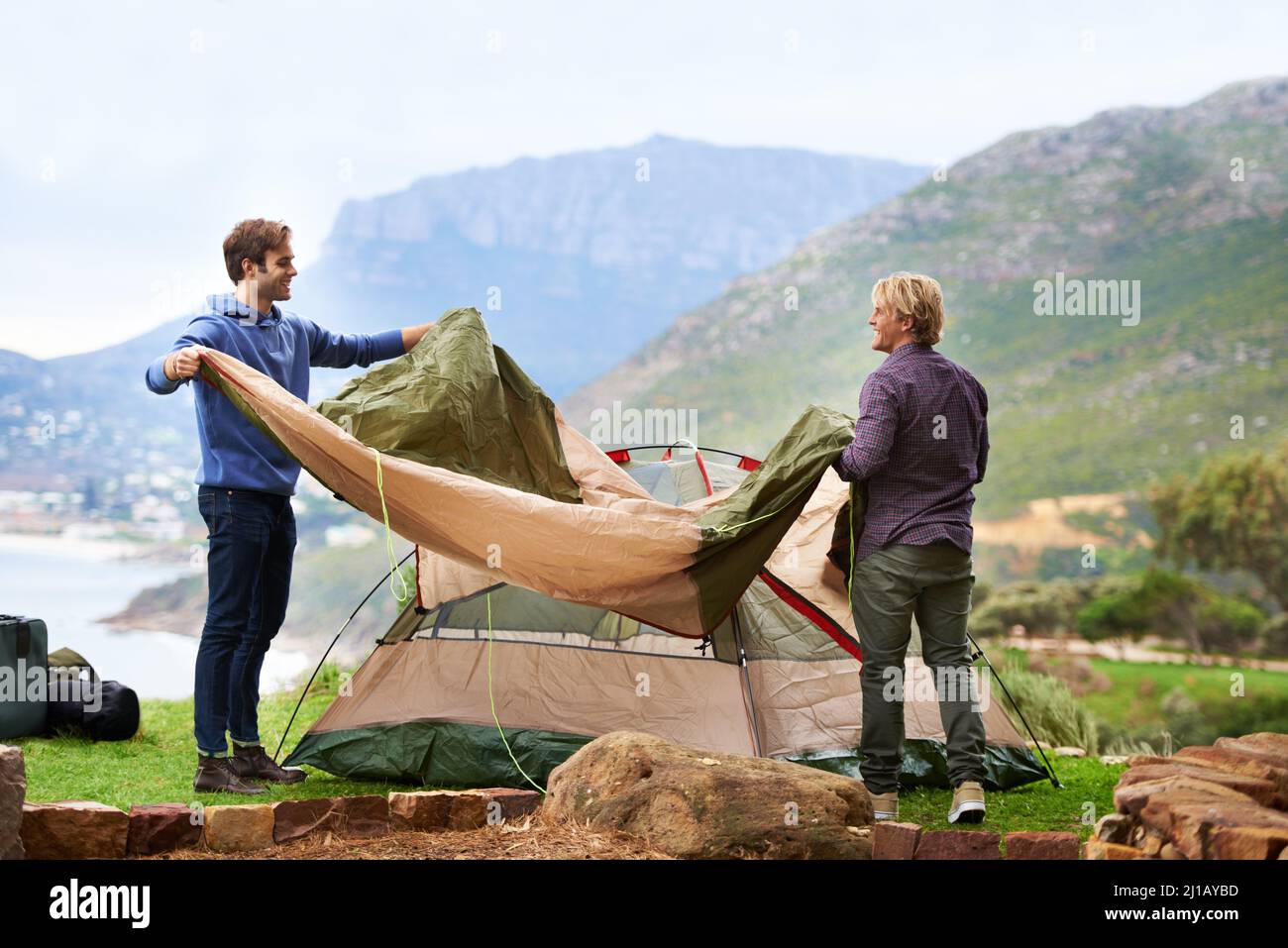 Camping is great fun. Shot of a two male friends at the campsite Stock ...