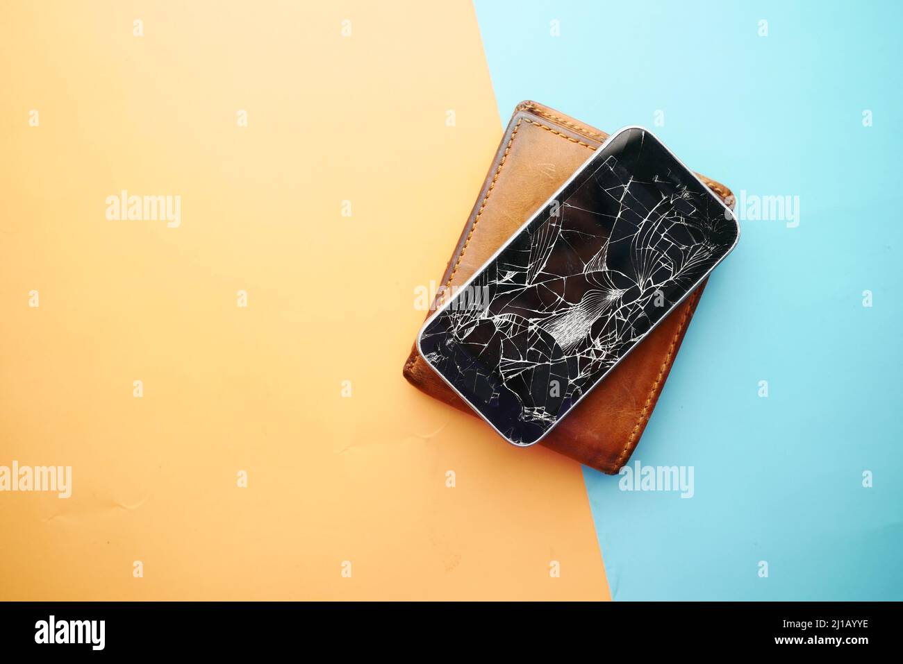 Top view of broken smart phone on color background Stock Photo - Alamy