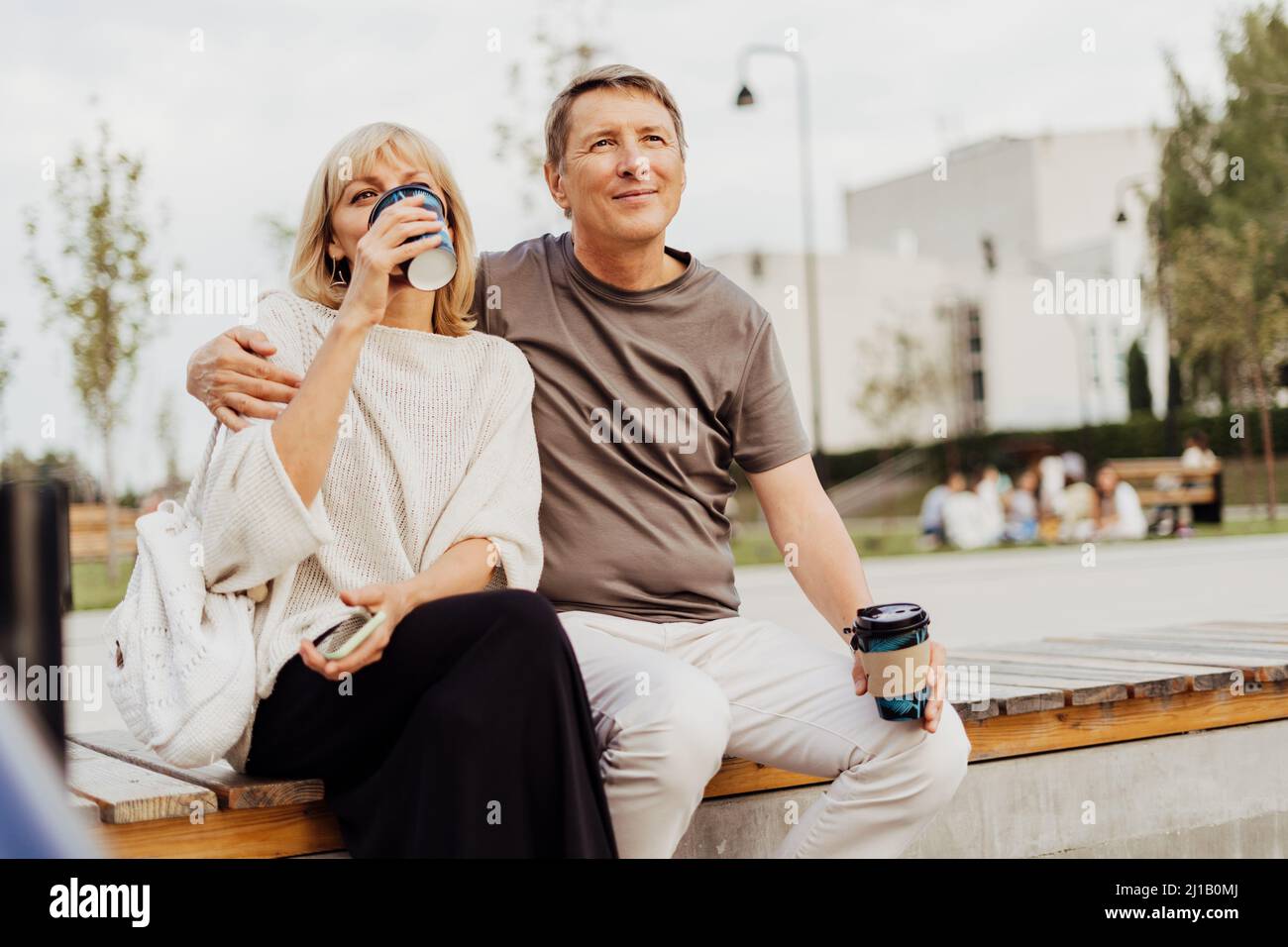An Adult Mature Happy Couple In Love Sitting On Bench Outdoors In City