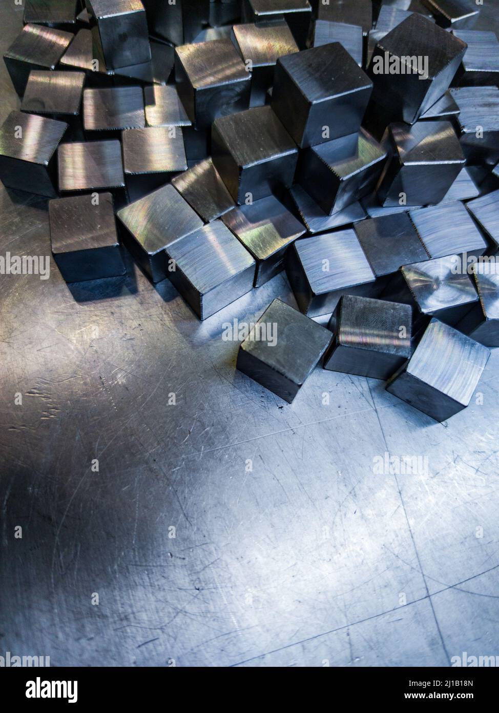 pile of small machined shiny steel cubes on metal surface Stock Photo ...