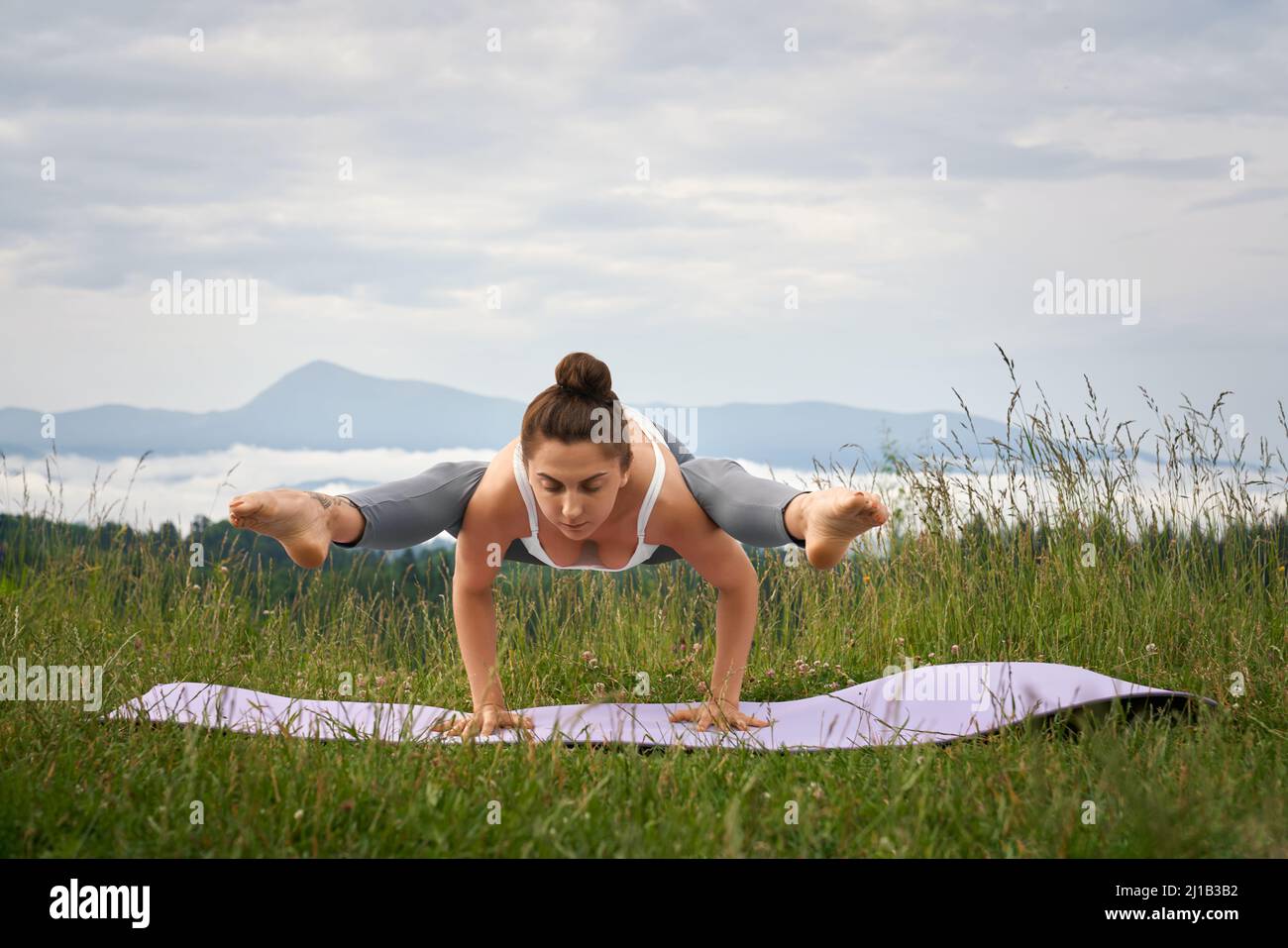 Athletic woman in sport clothes doing yoga exercise for balancing with ...