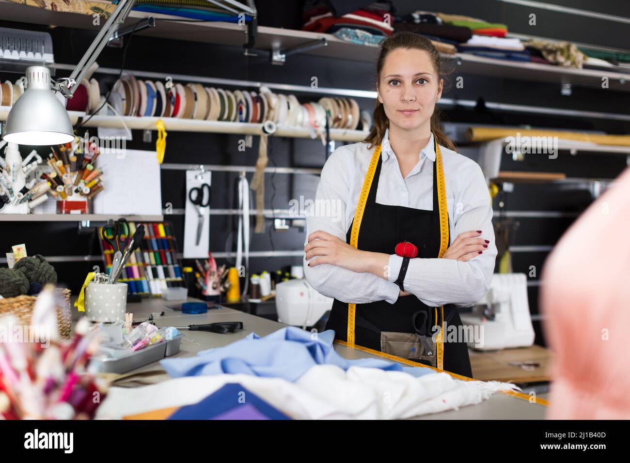 Portrait of woman designer who is standing on her workplace in time ...