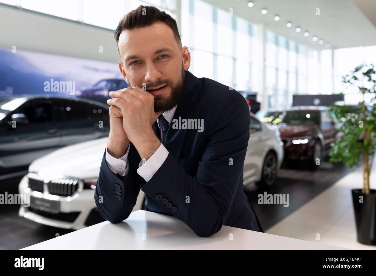 portrait of a businessman in the car showroom of a car dealership Stock ...