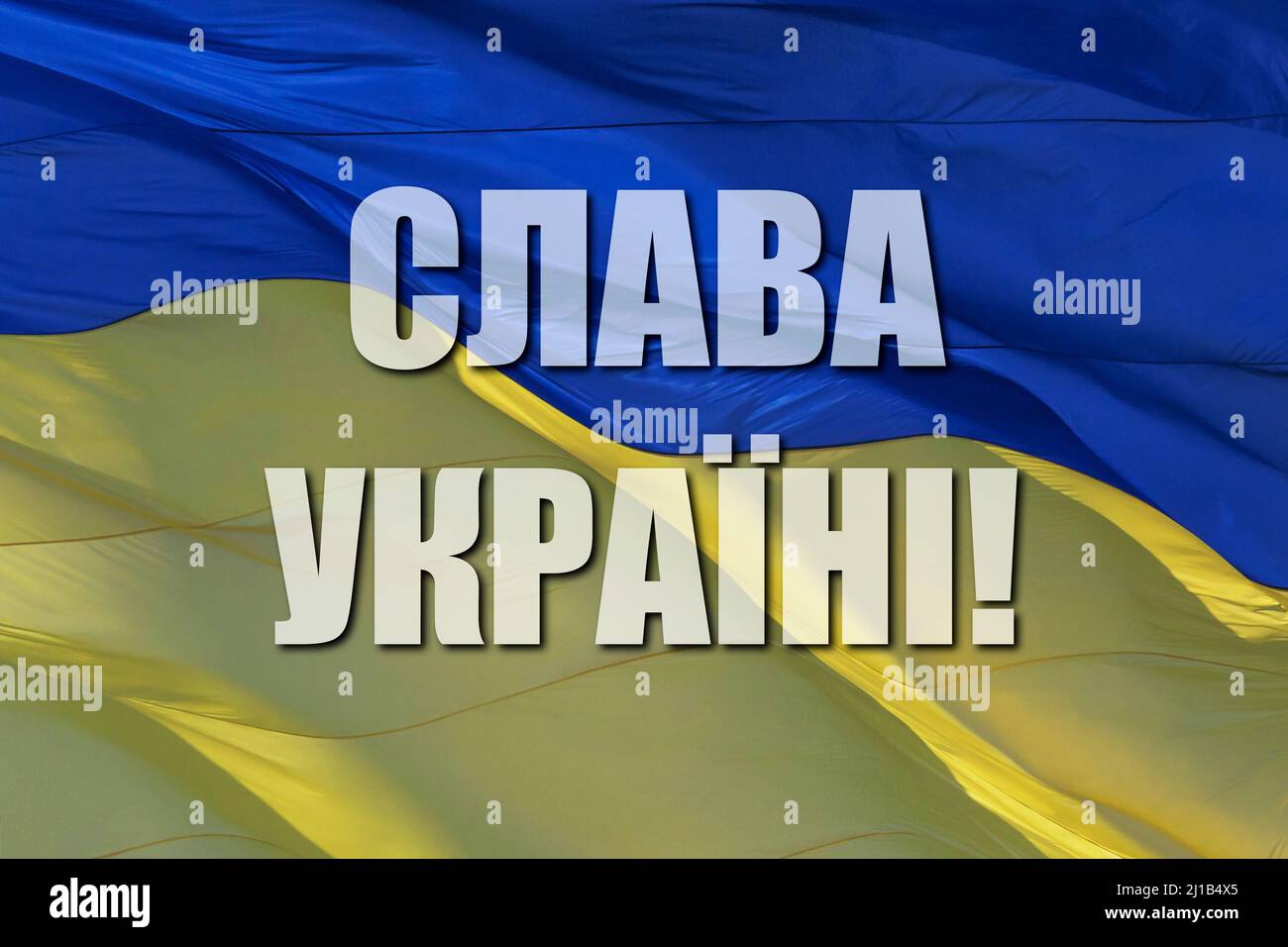 slogan Glory to Ukraine in Ukrainian on waved national flag Stock Photo ...