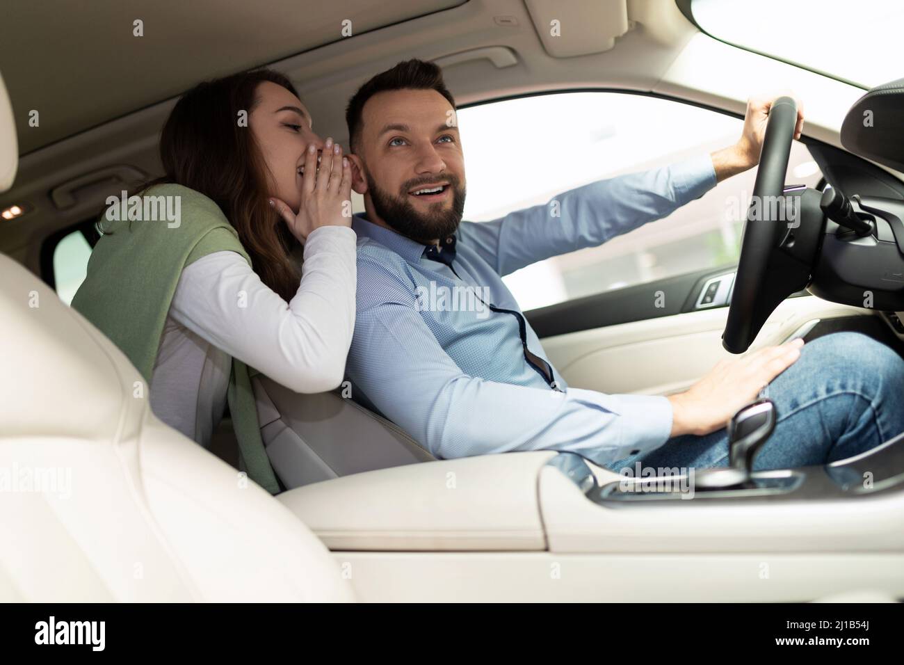 a young married couple in a car dealership chooses a new car whispering ...