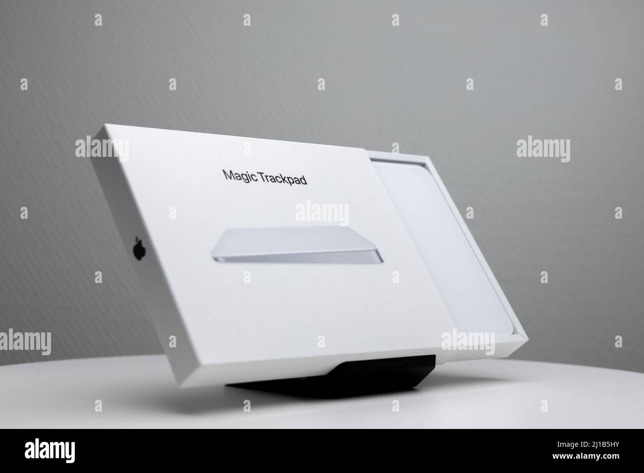 Gray backdrop with white half opened package box of Mac Apple magic ...