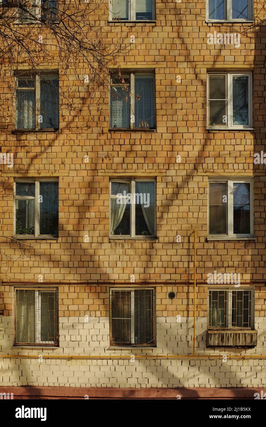 Russian panel house and windows of different apartments. Shadow from ...