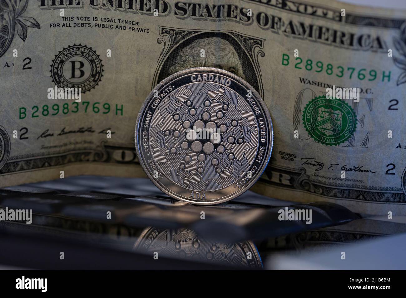 Cardano ADA cryptocurrency physical coin placed on computer keyboard ...