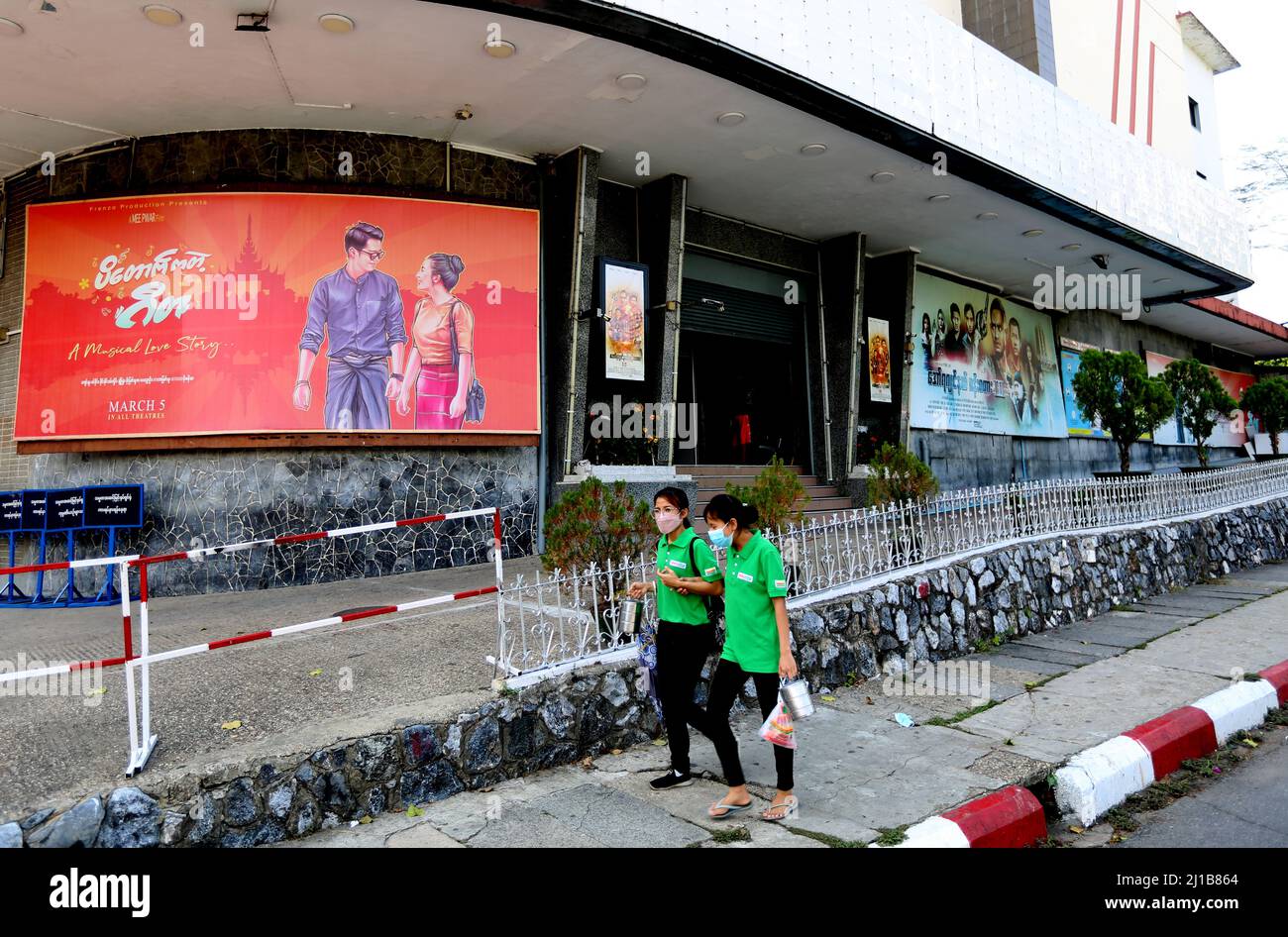Yangon, Myanmar. 24th Mar, 2022. People walk past the shuttered Thamada ...