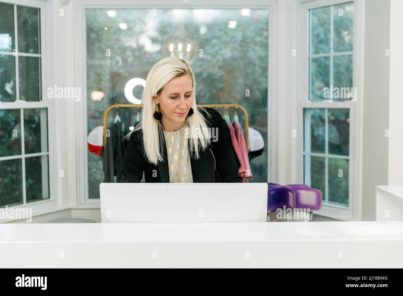 A female small business owner of a medical spa and retail shop standing ...