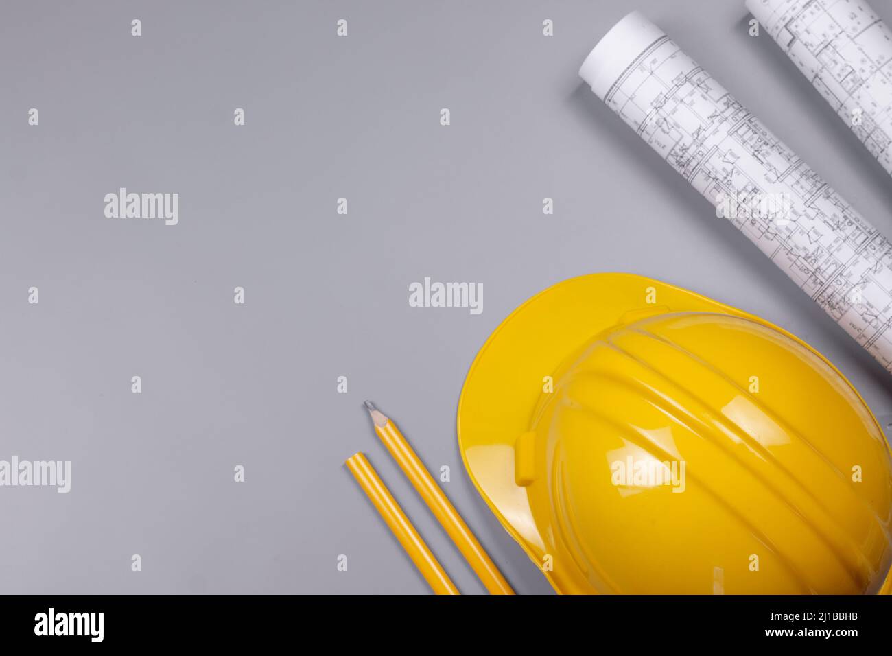 Hard hat (Helmet), project drawings roll and pencils, on grey ...