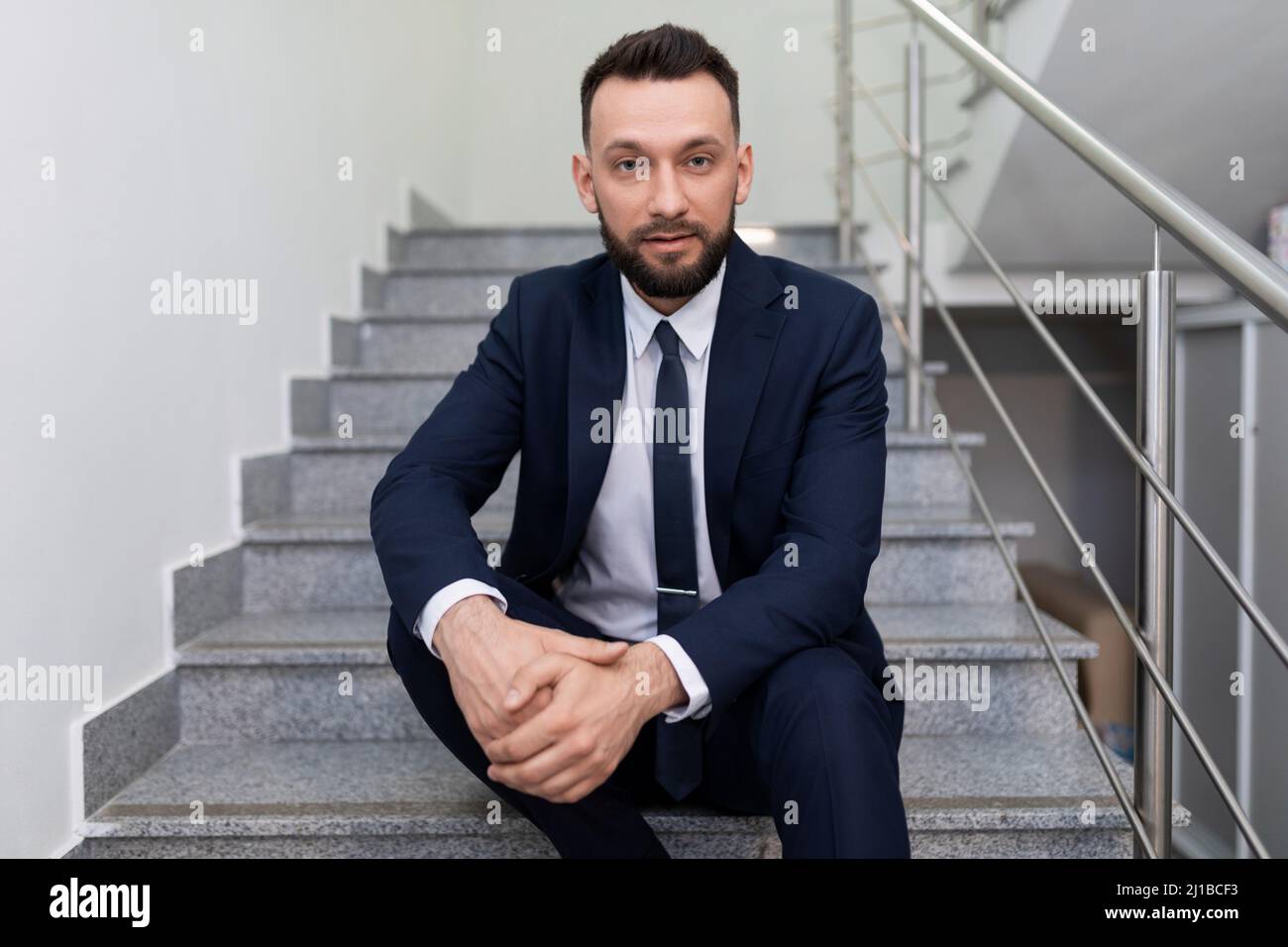 male businessman sitting on the steps enters the camera Stock Photo - Alamy