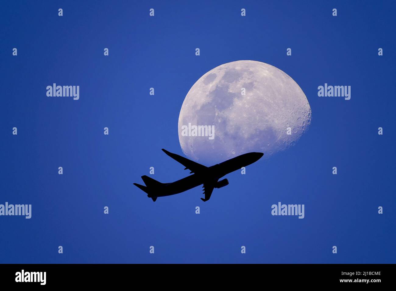 an airplane flying across a moon or Passenger plane - airliner passes ...