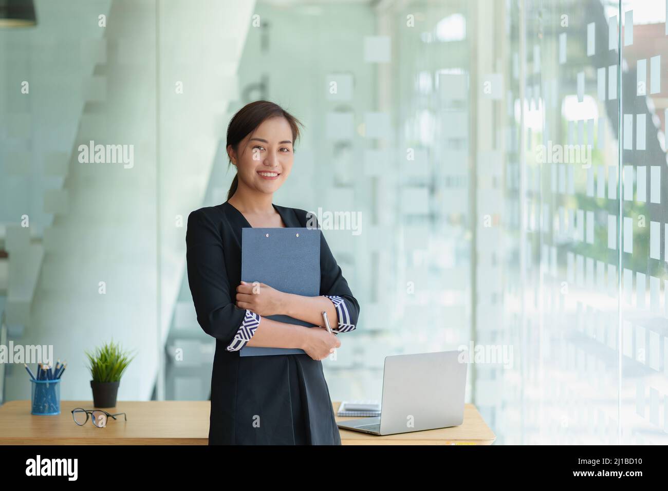 Secretary checking schedule at front of boss room Stock Photo - Alamy