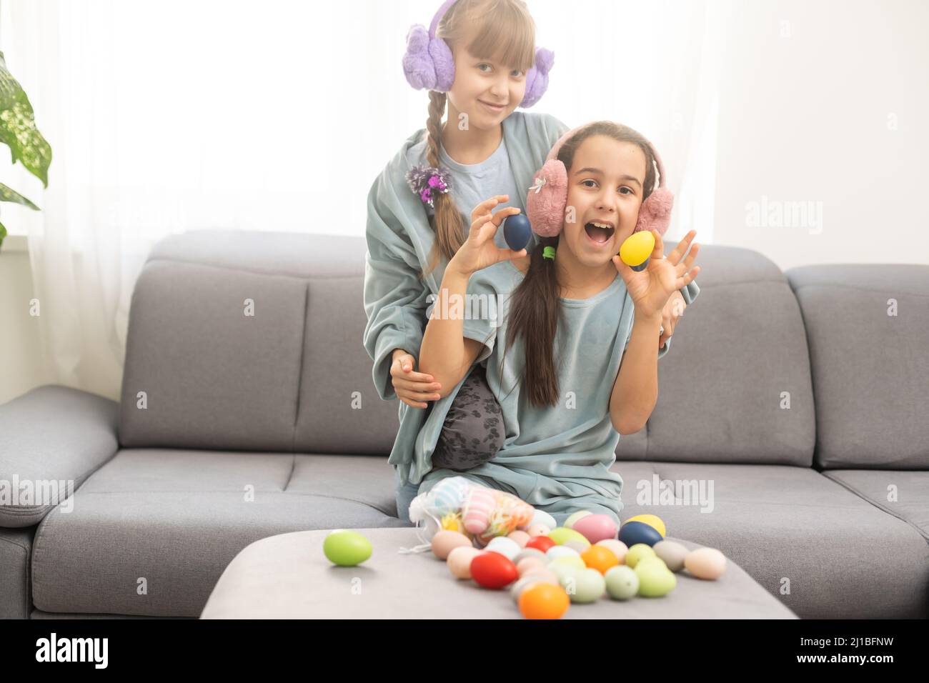 two little girls play with easter eggs. Easter hunt concept Stock Photo ...