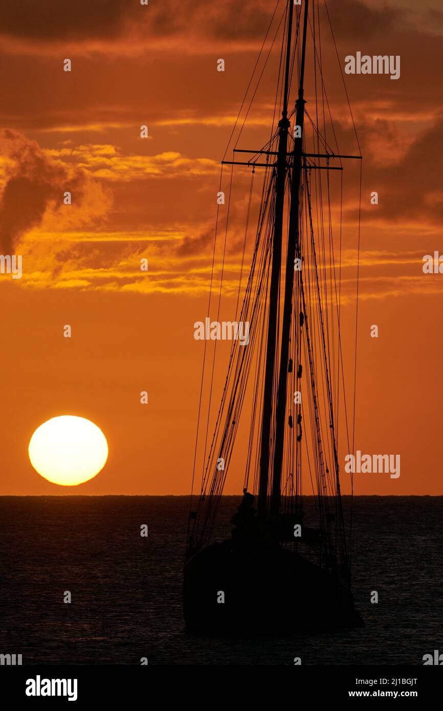 A scenic view of the sunset over the sea and a ship floating Stock ...