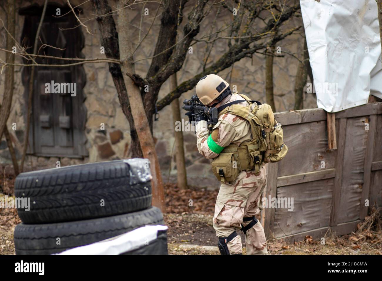 airsoft game, a player in a uniform and in a helmet with an airsoft ...