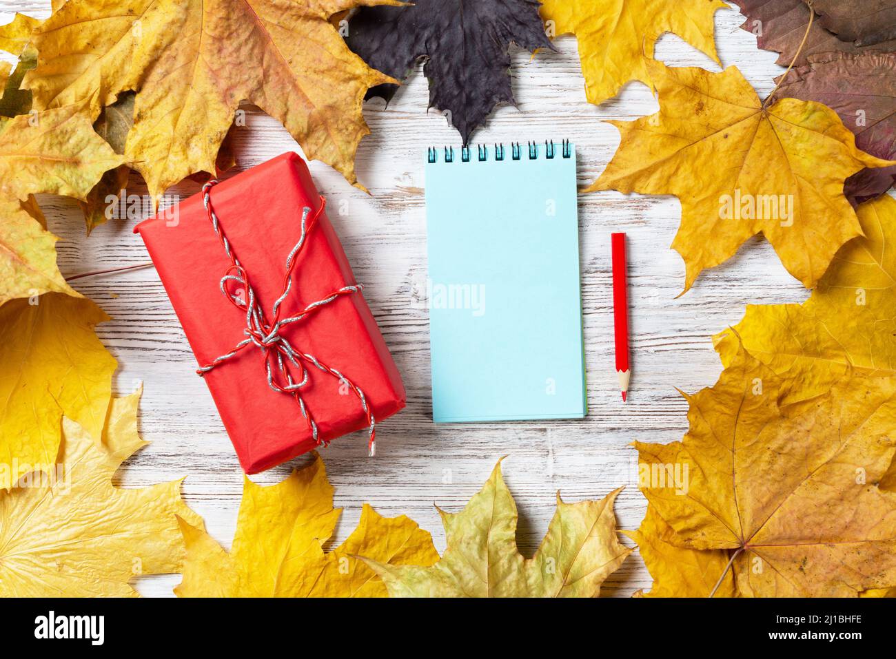 Spiral notepad with pen and gift box on desk Stock Photo - Alamy