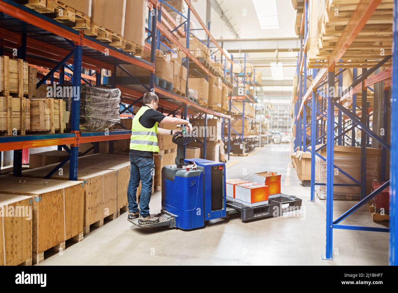 Storehouse employee in uniform working on forklift in modern automatic ...