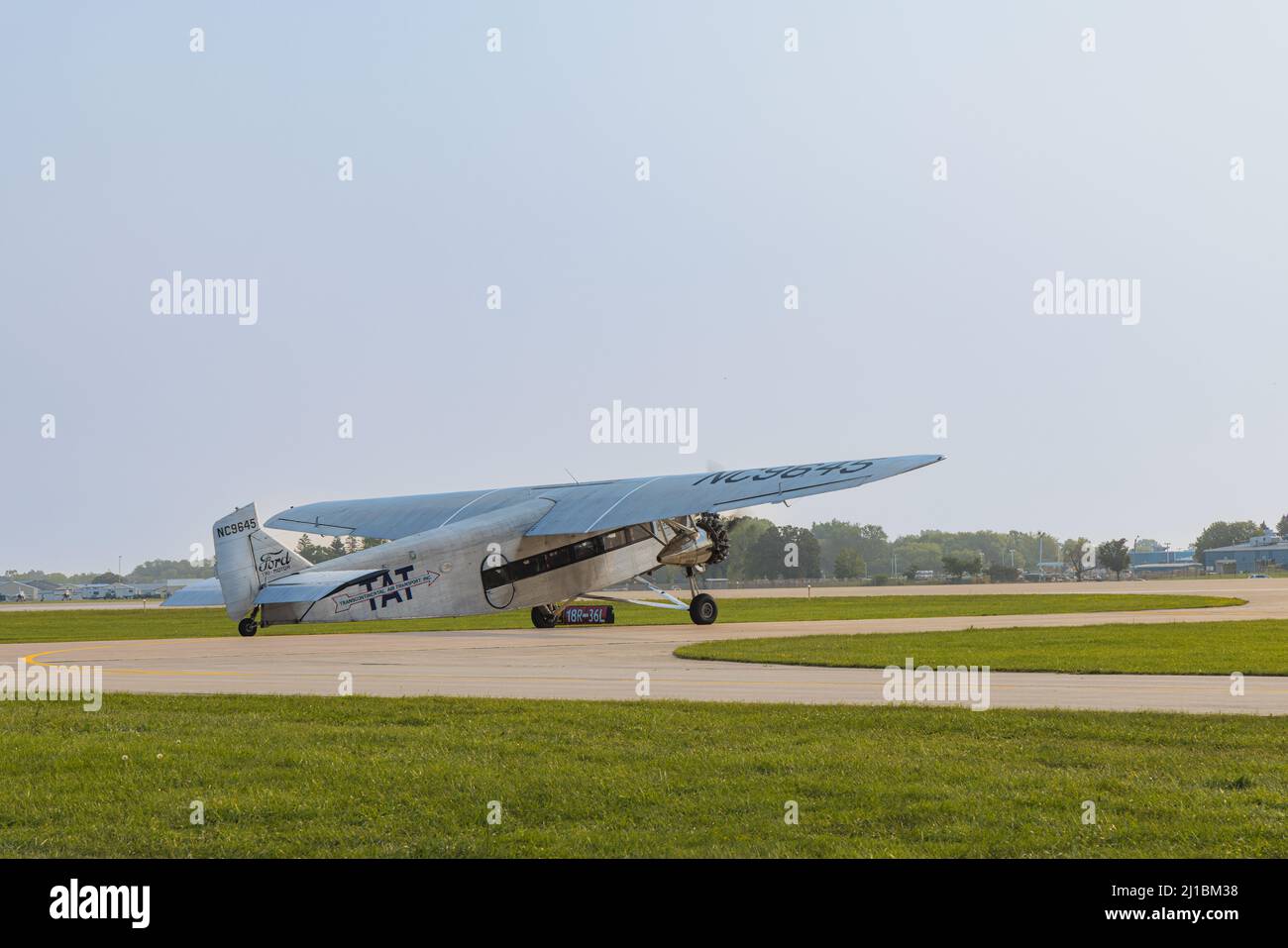 A Vintage silver tri-engine aircraft on the runway Stock Photo - Alamy