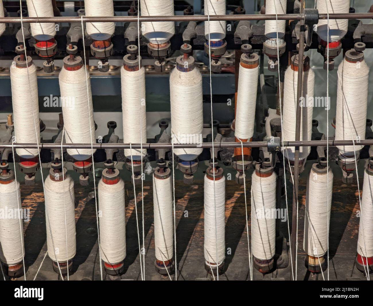 A row of a machine in a thread factory Stock Photo - Alamy