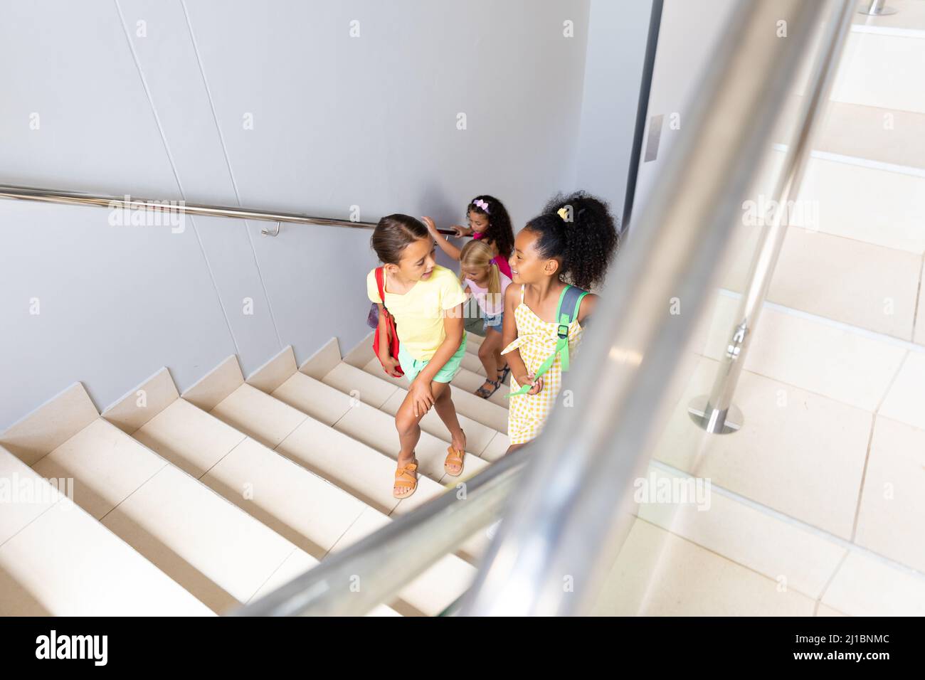 High angle view of multiracial elementary schoolgirls climbing steps in ...