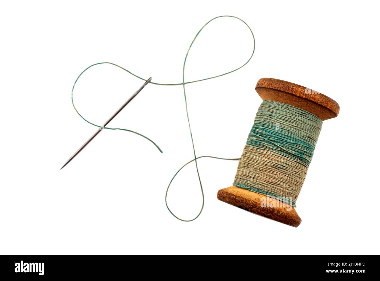 Old retro needle and thread on a white background. Spool of colored ...