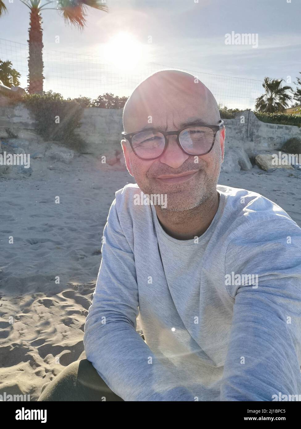 The Attractive bald middle-aged Spanish man with glasses smiling and ...
