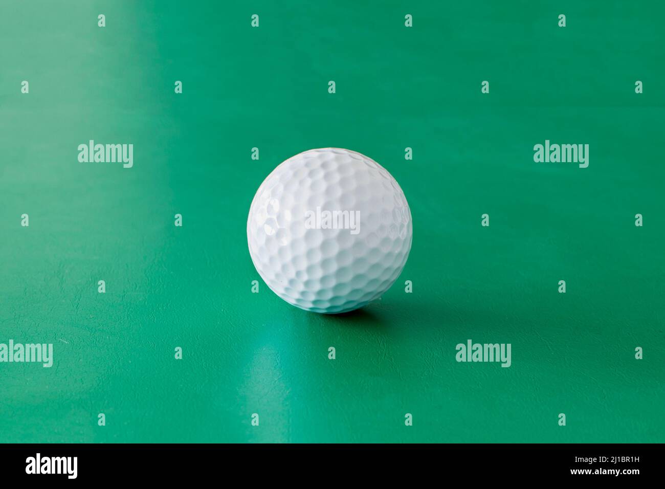 Single golf ball on the green background Stock Photo - Alamy
