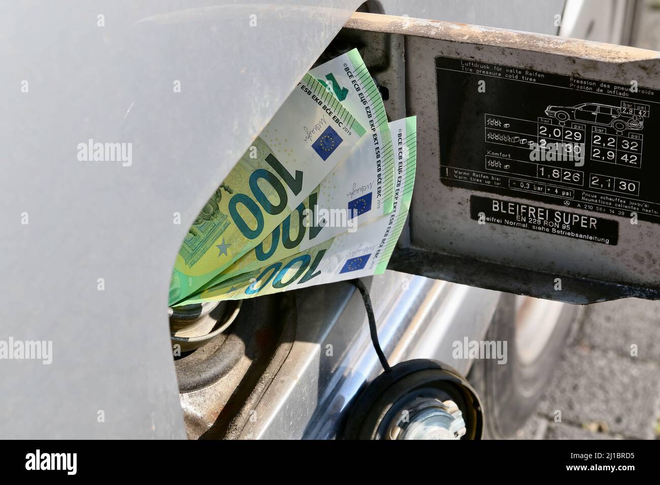 Money for fuel on gasoline inlet of a car Stock Photo - Alamy