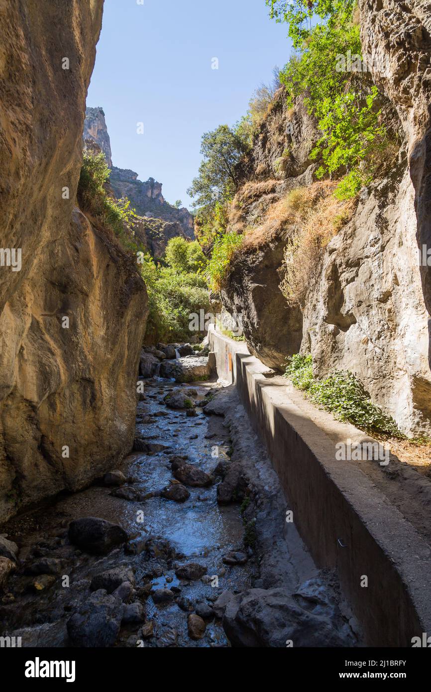 Hiking the Los Cahorros trail through a gorge with a stream near ...