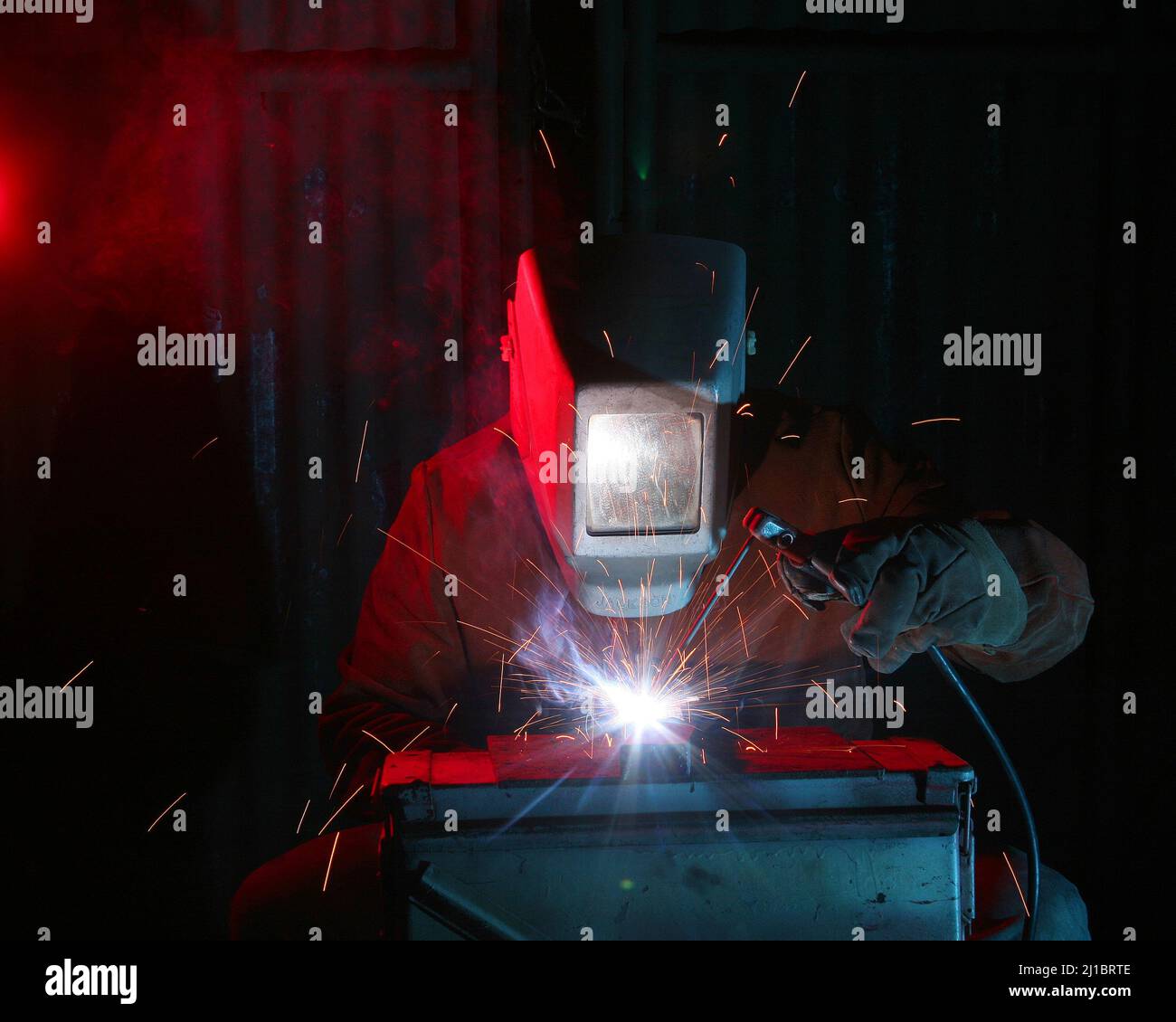 A welder working attaching metal parts together in the dark Stock Photo ...
