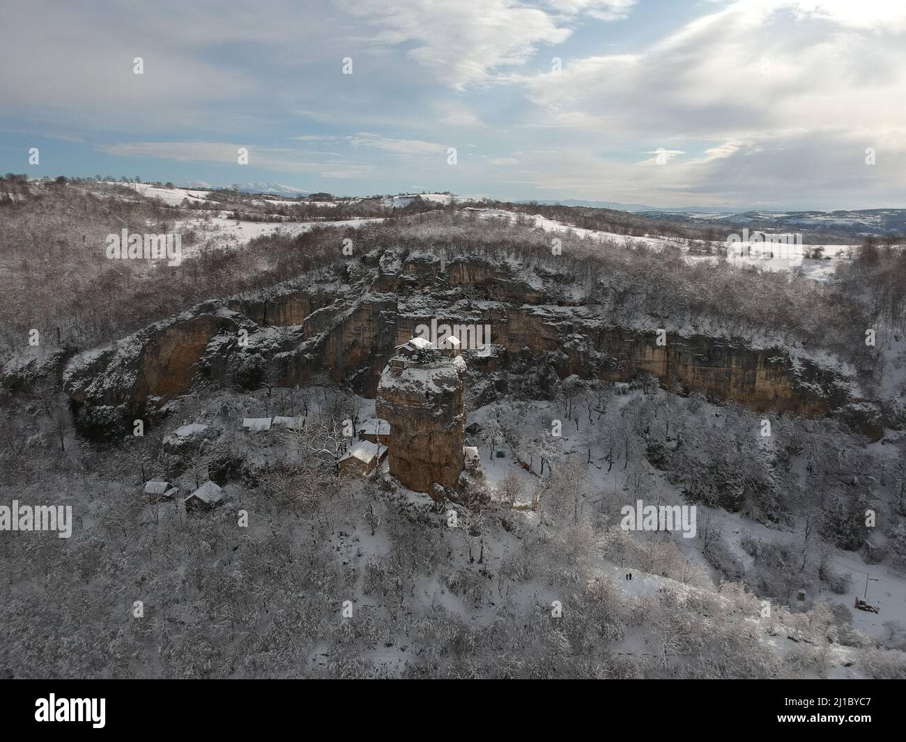 A snow covered Katskhi Pillar in Georgia. A church which sits on top of ...