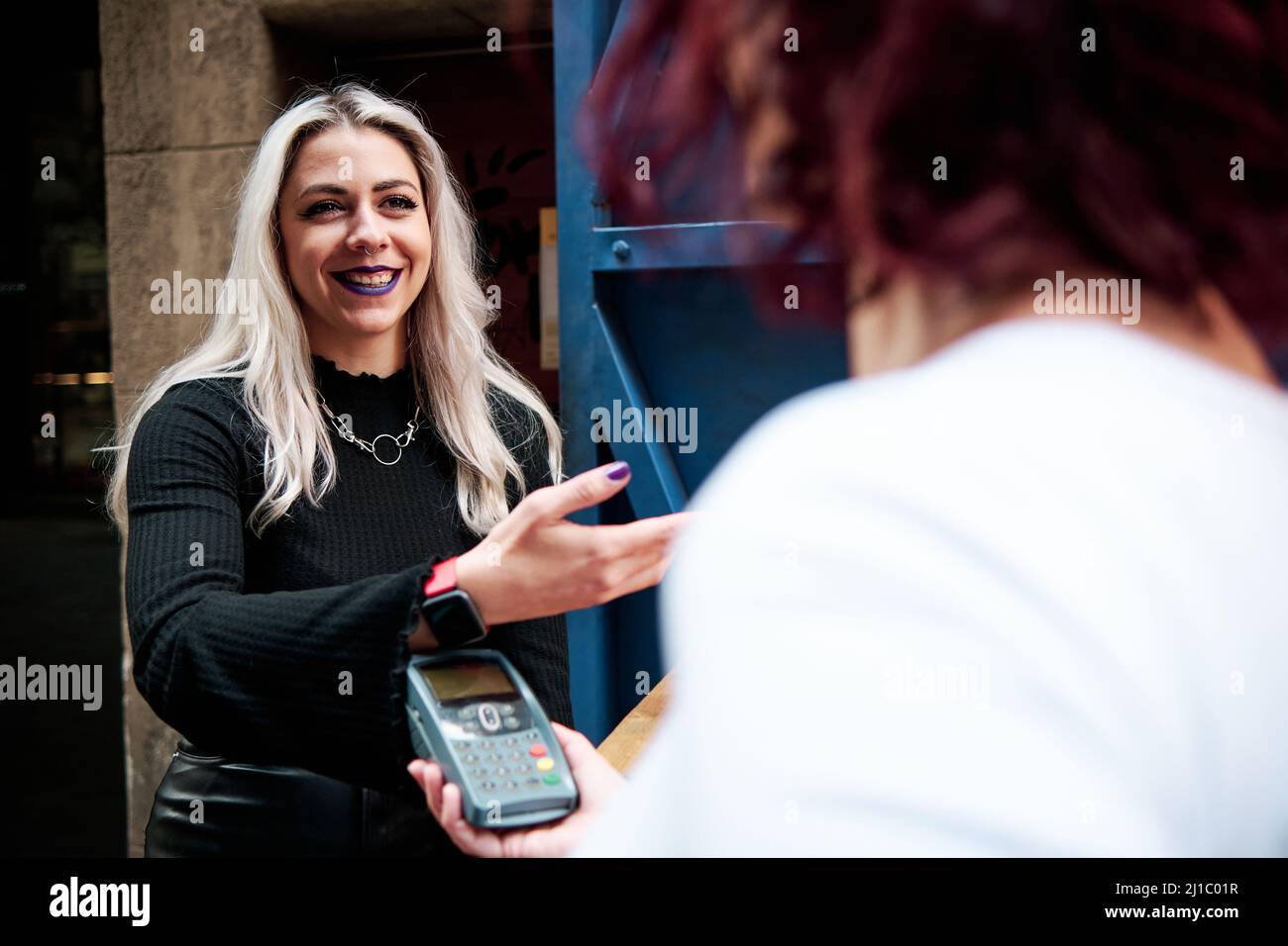 Alternative woman using wireless terminal for contactless payment with ...