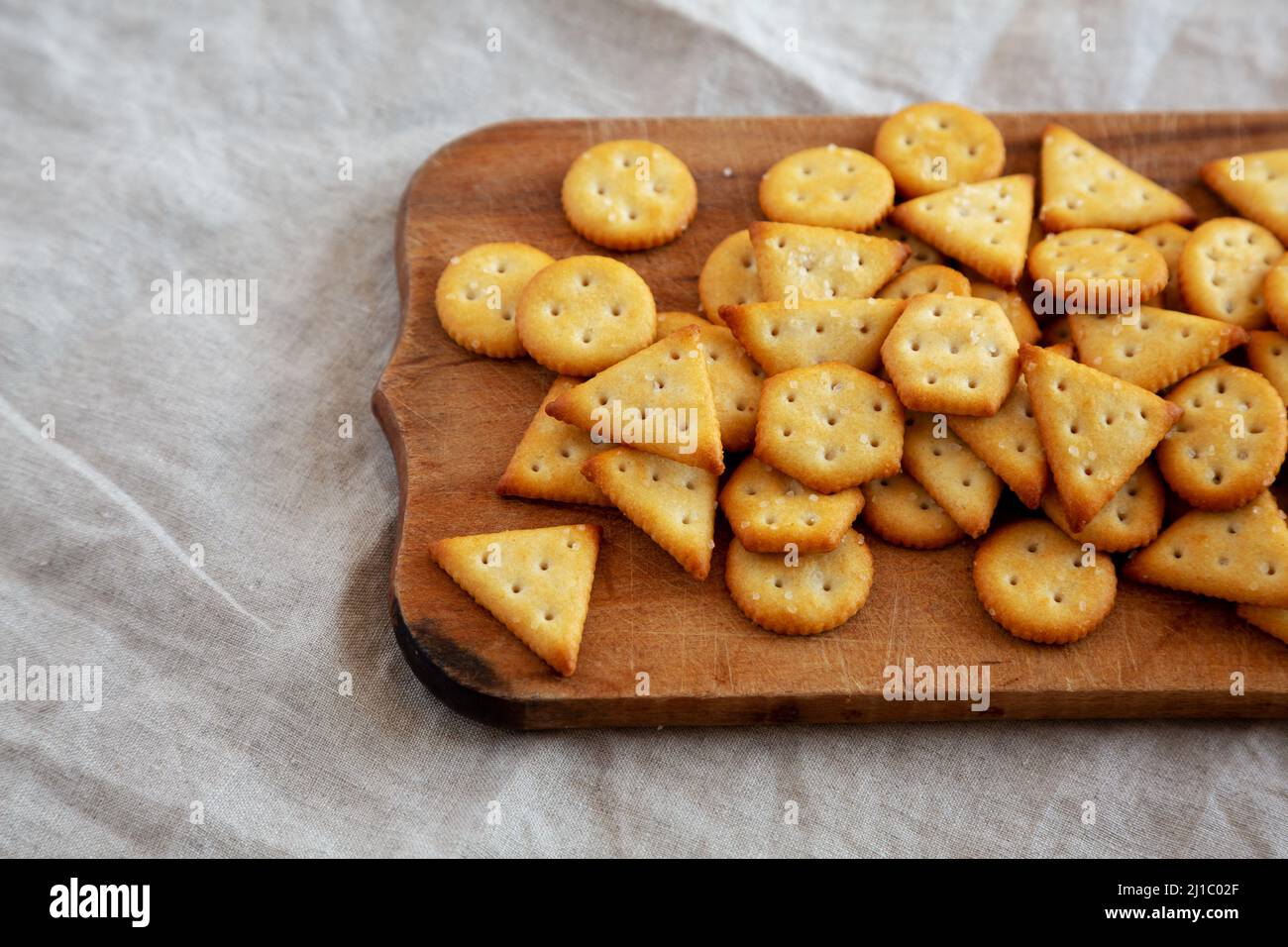 Homemade Salty Crackers on a Rustic Wooden Board, low angle view. Space ...