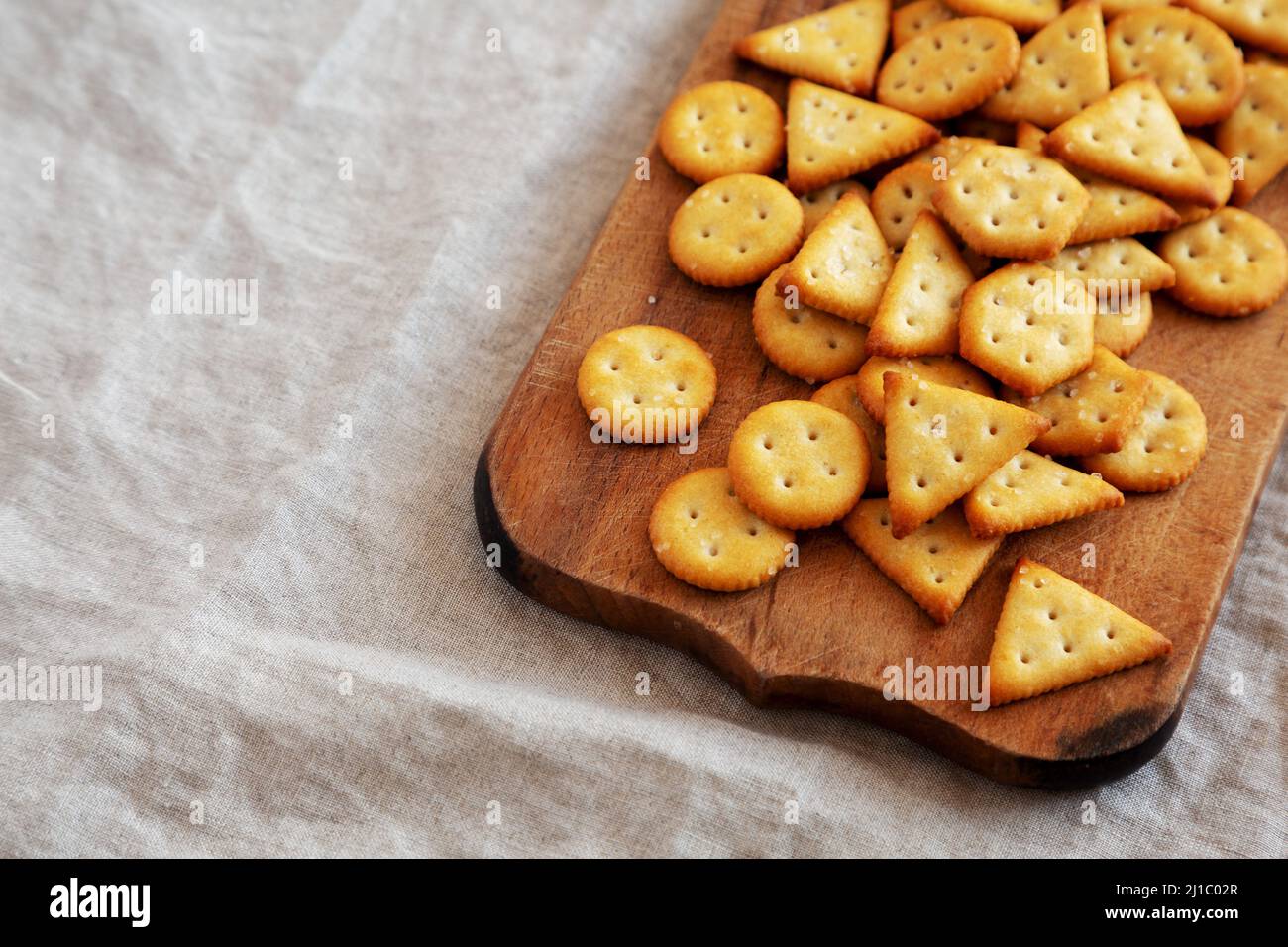 Homemade Salty Crackers on a Rustic Wooden Board, low angle view. Space ...
