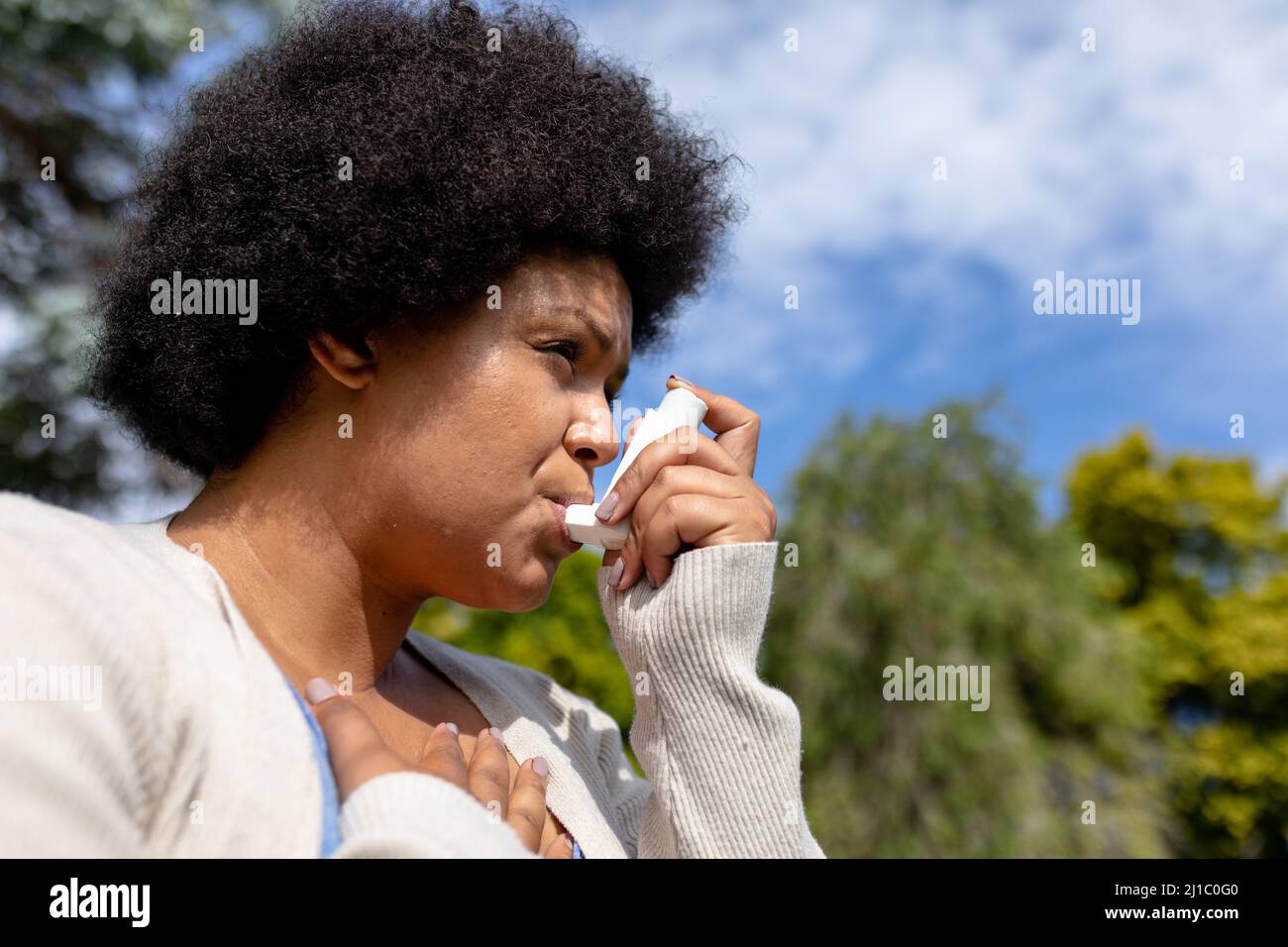 Close-up african american mid adult woman with hand on chest using ...