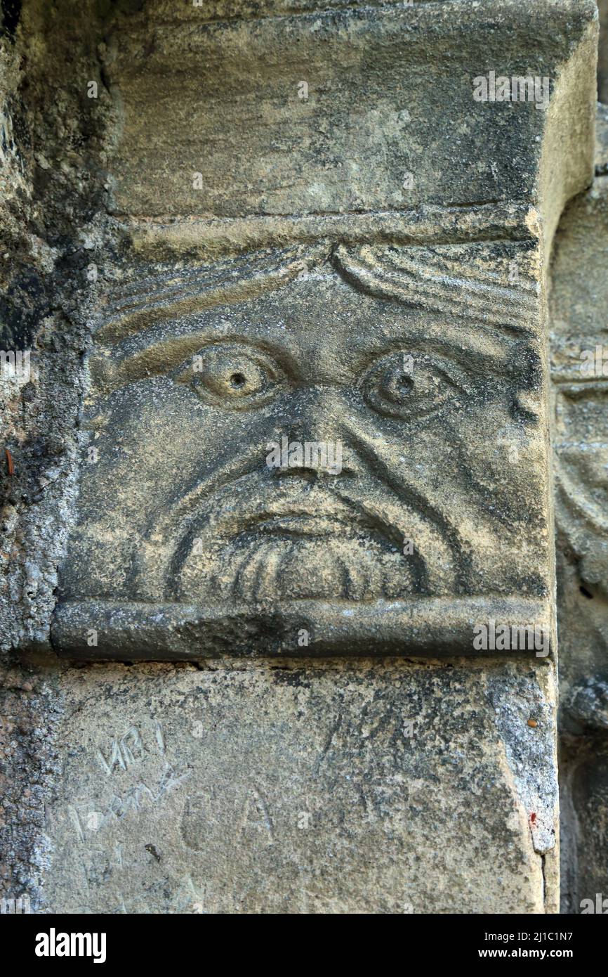 Carved human face on the capital of the North Doorway to the church of ...