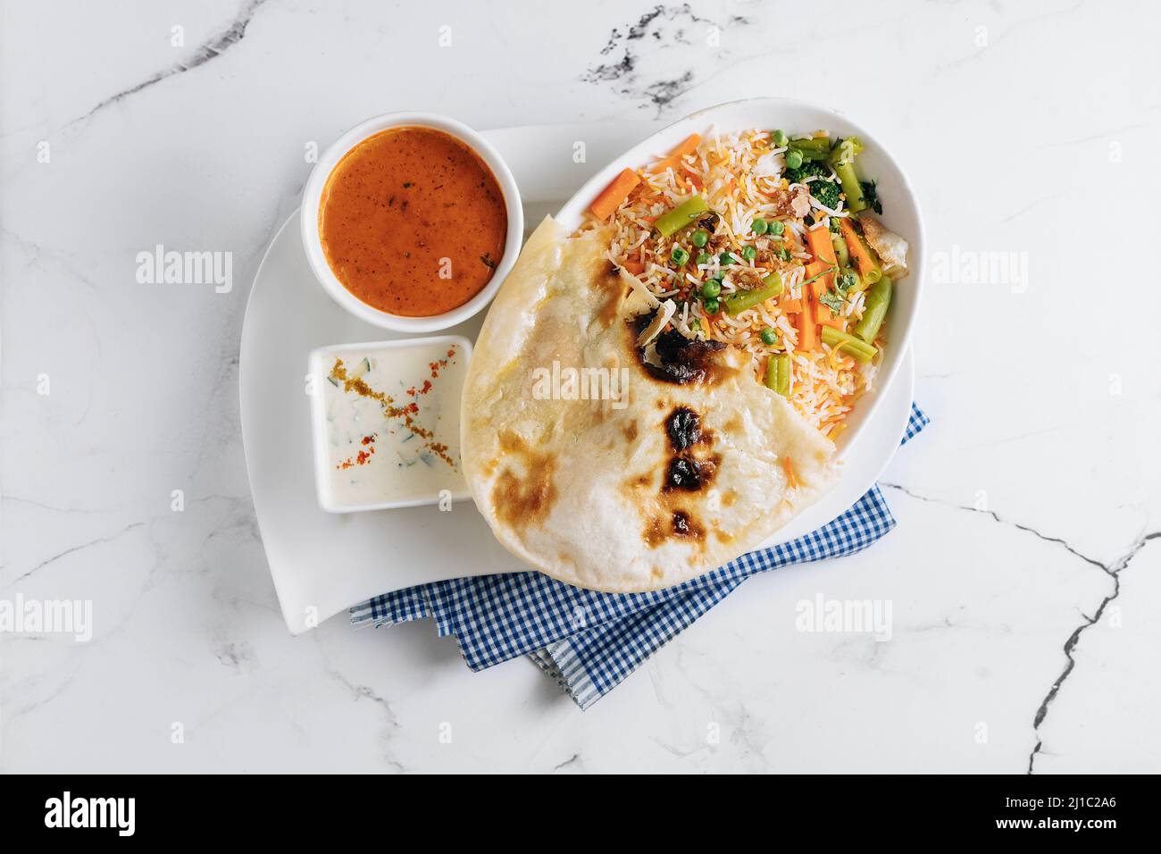 vegetable biryani with raita and sauce in a dish isolated on napkin ...