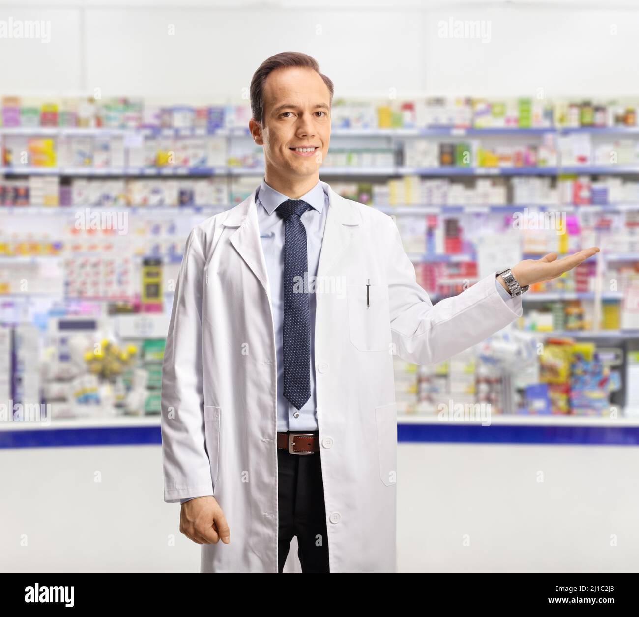 Male pharmacist showing with hand inside a pharmacy Stock Photo - Alamy