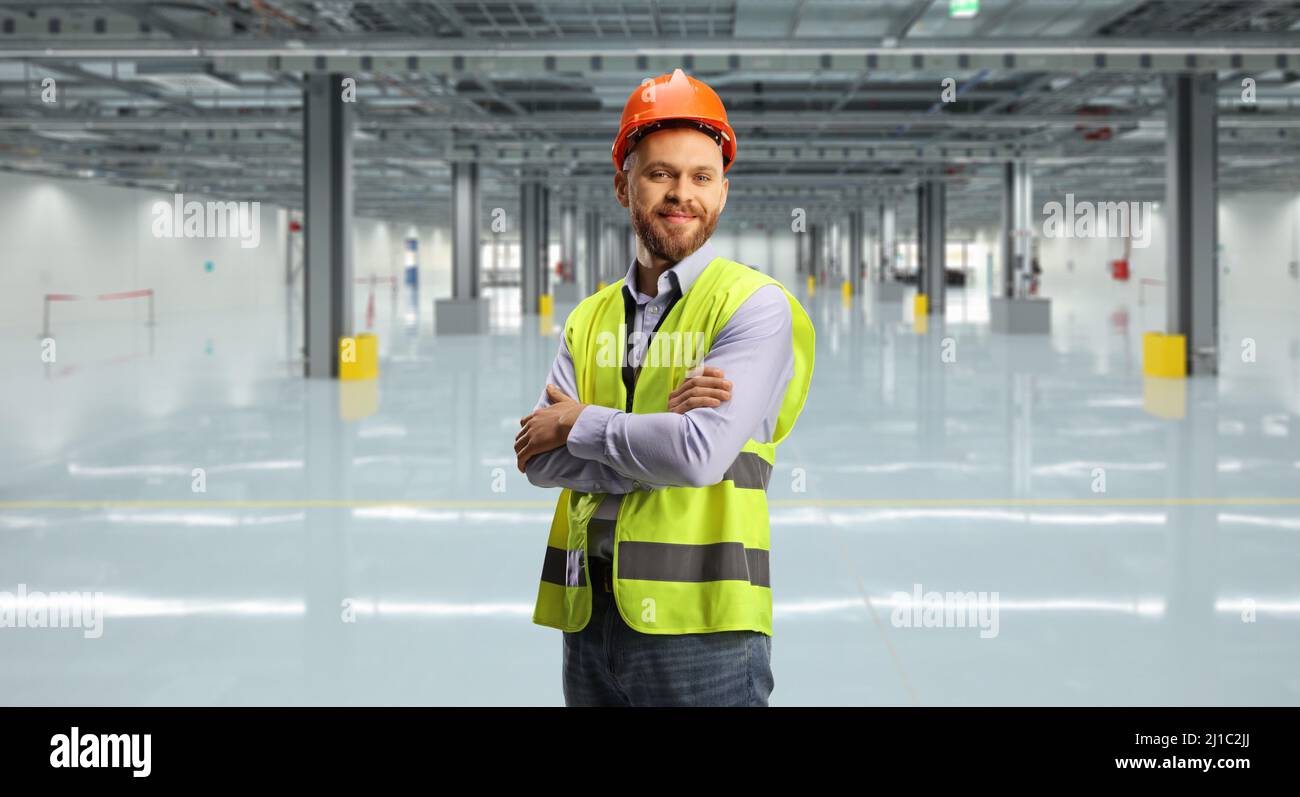Engineer wearing a reflective vest and helmet posing in a hall Stock ...